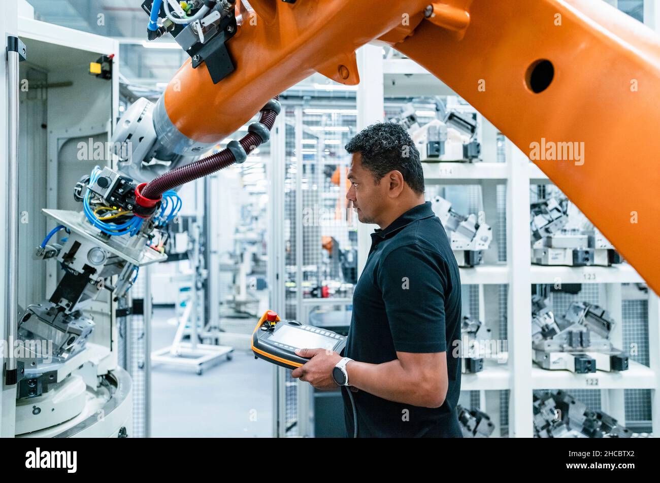 Maintenance engineer operating robot arm in industry Stock Photo - Alamy