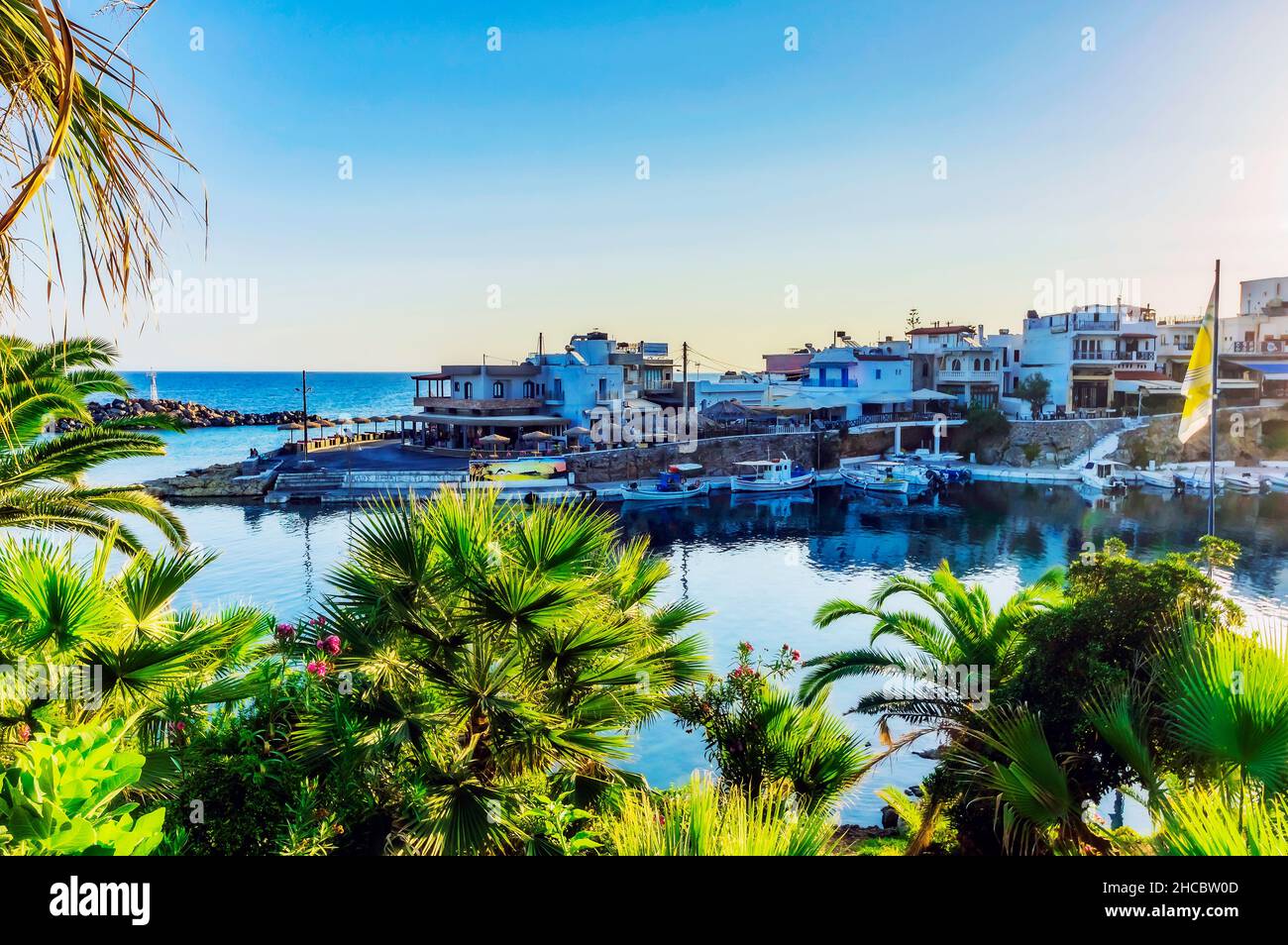 Greece, Crete, Sissi, Marina of coastal village with palm trees in ...
