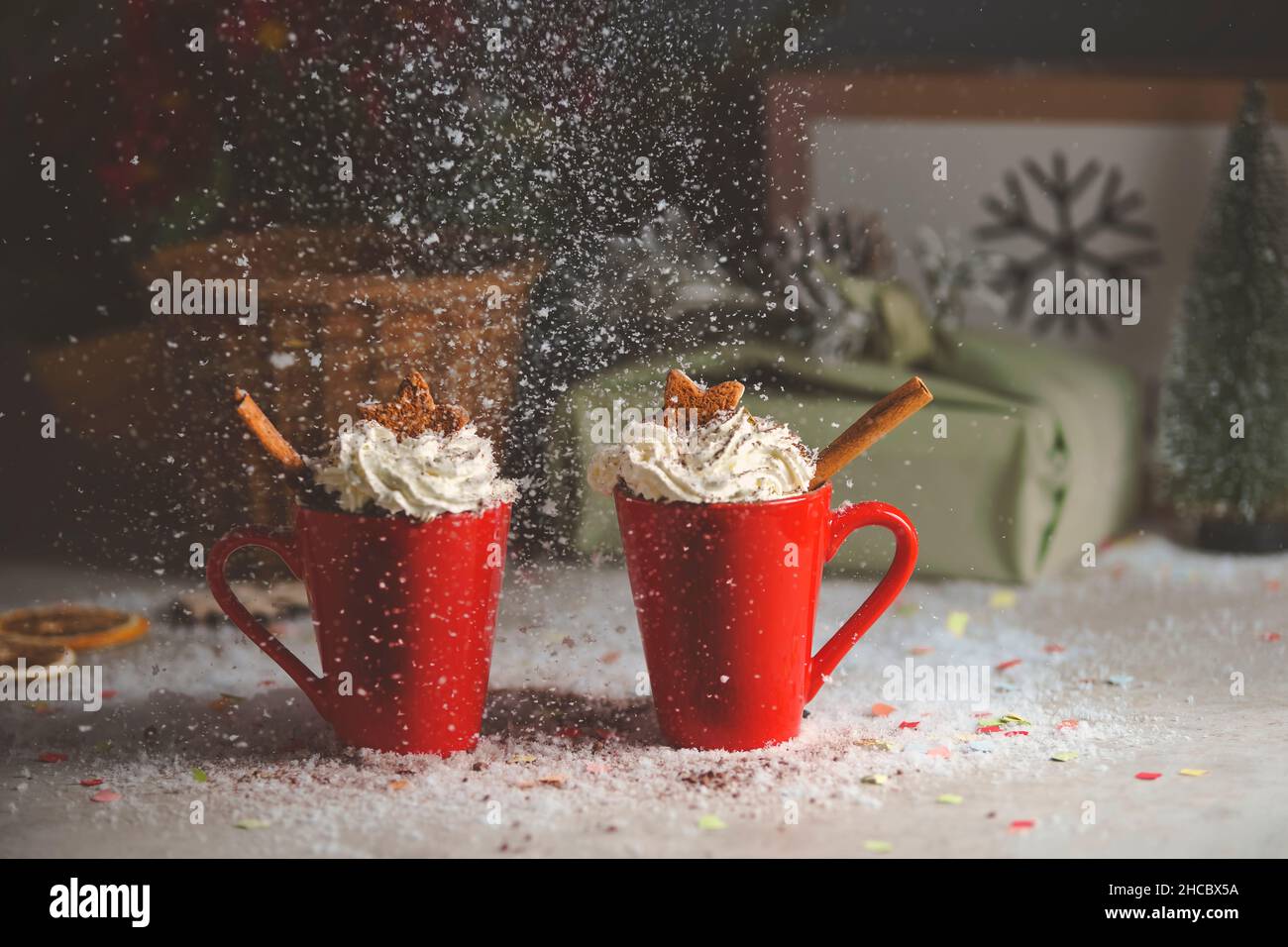 Two red mugs with hot chocolate, whipped cream, Christmas star cookie ...