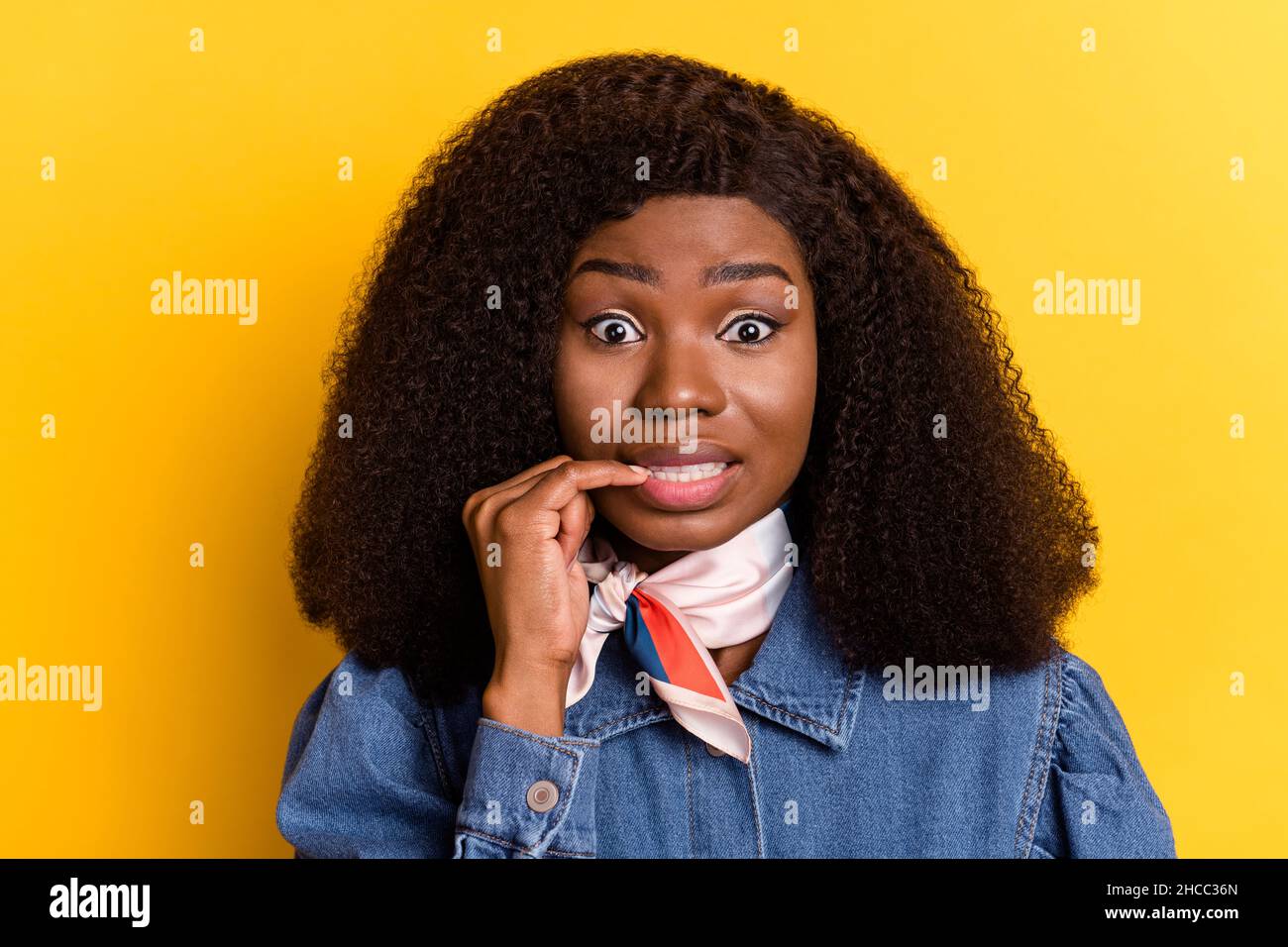 Photo of questioned dark skin lady teeth biting finger nail look camera ...