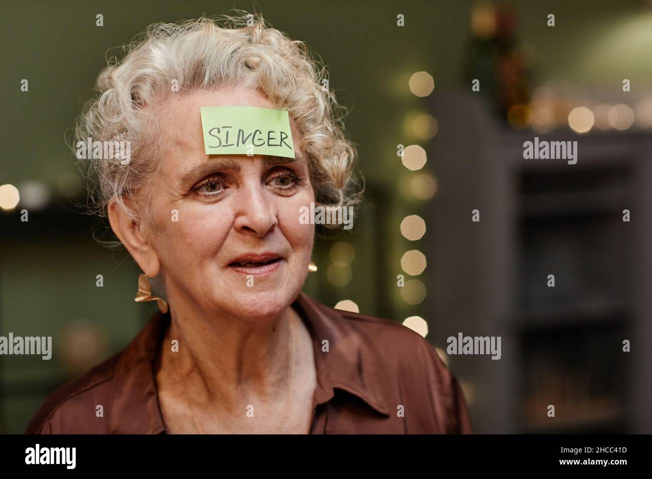 Portrait of beautiful aged woman with piece of paper on her forehead ...