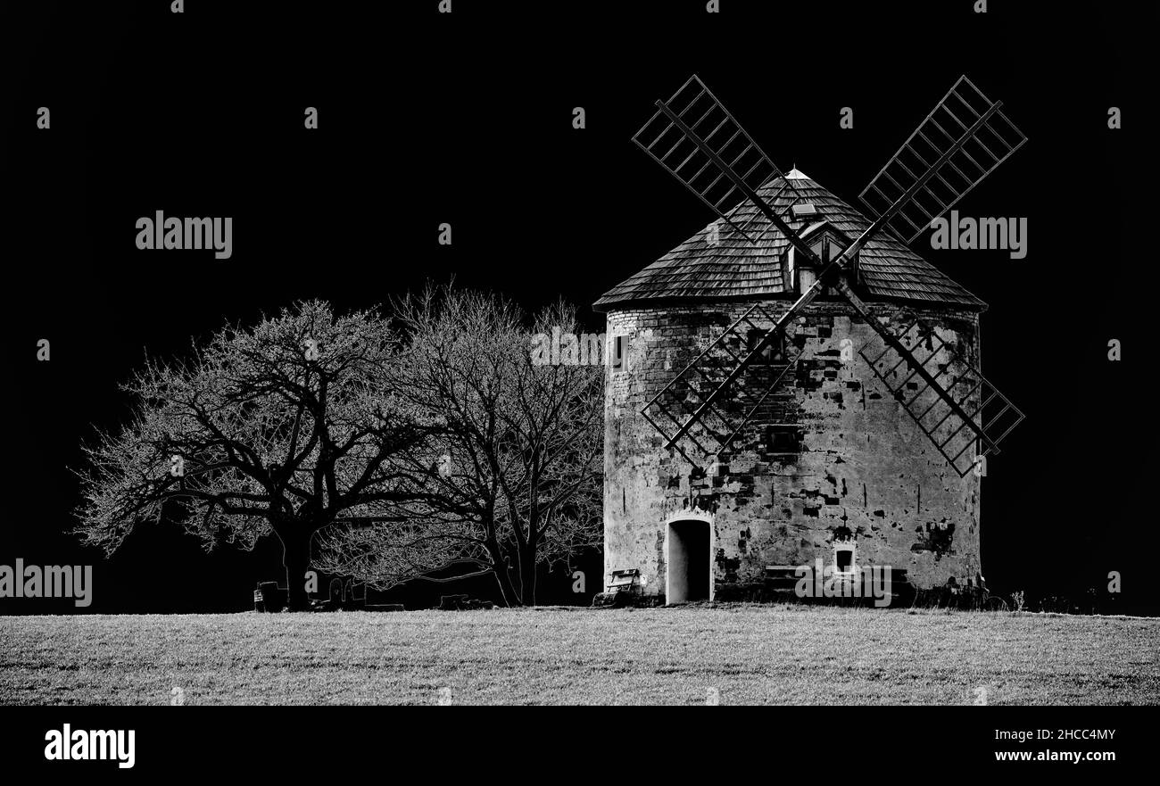 Grayscale shot of an old windmill with trees in Moravia, Czech Republic ...
