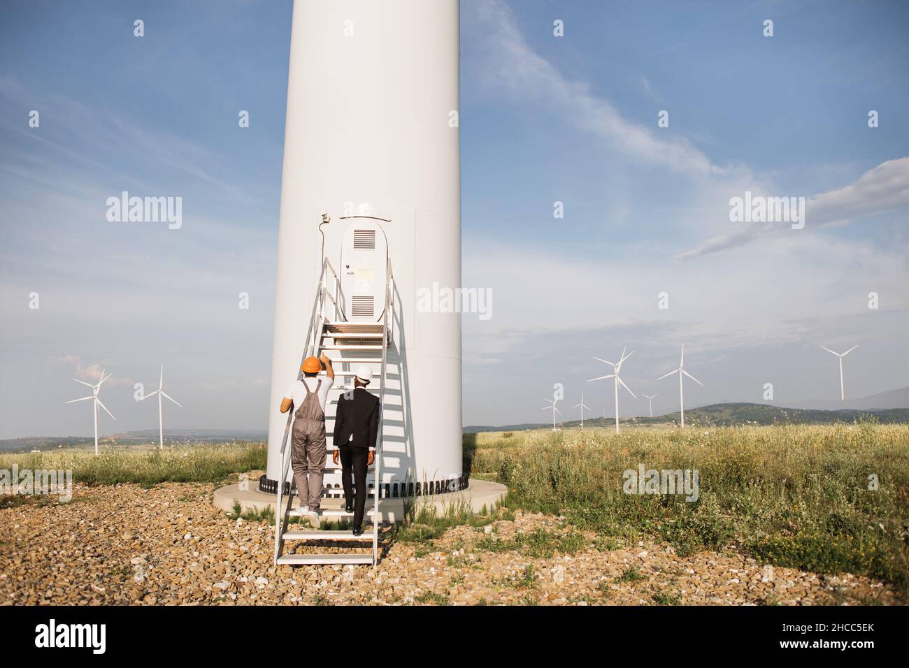 African american inspector in black suit and white helmet talking with ...
