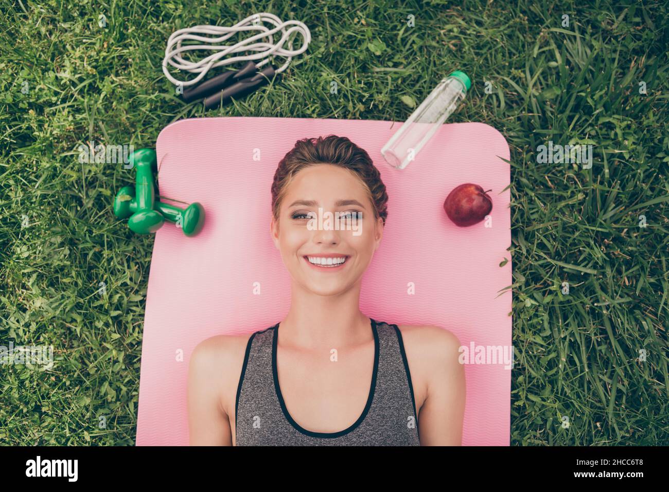 Top above view photo of cheerful sportswoman lay carpet enjoy rest wear ...