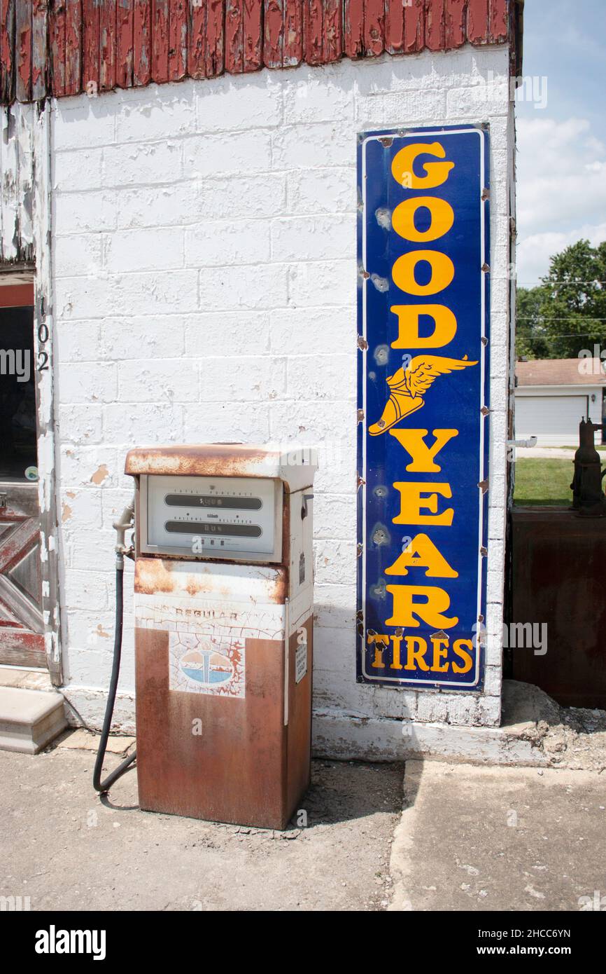 old rusty gas pump and metal Goodyear tyres sign on wall of old gas ...