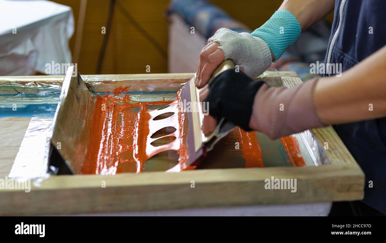 creating print on t-shirt in workshop. serigraphy production. printing ...