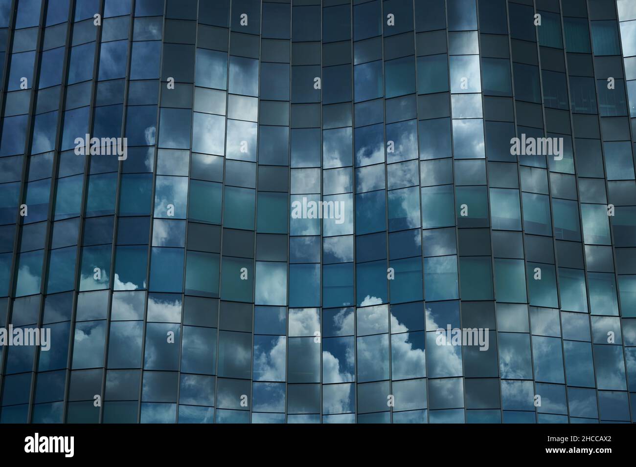 Cloudy sky reflection on a high glass building facade Stock Photo - Alamy