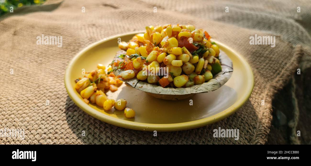 Steamed yellow sweet corn masala or corn chat prepared using butter ...