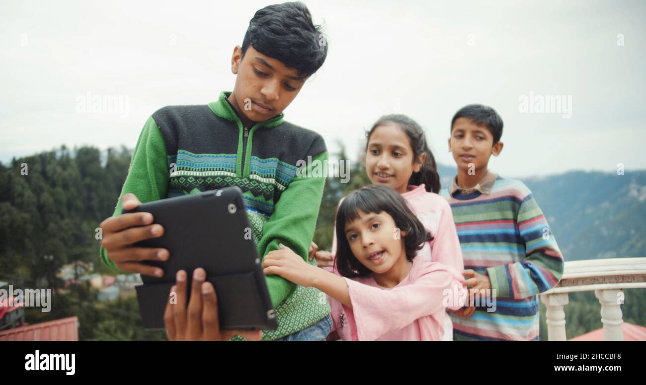Group of young South Asian friends on a balcony taking a selfie against ...