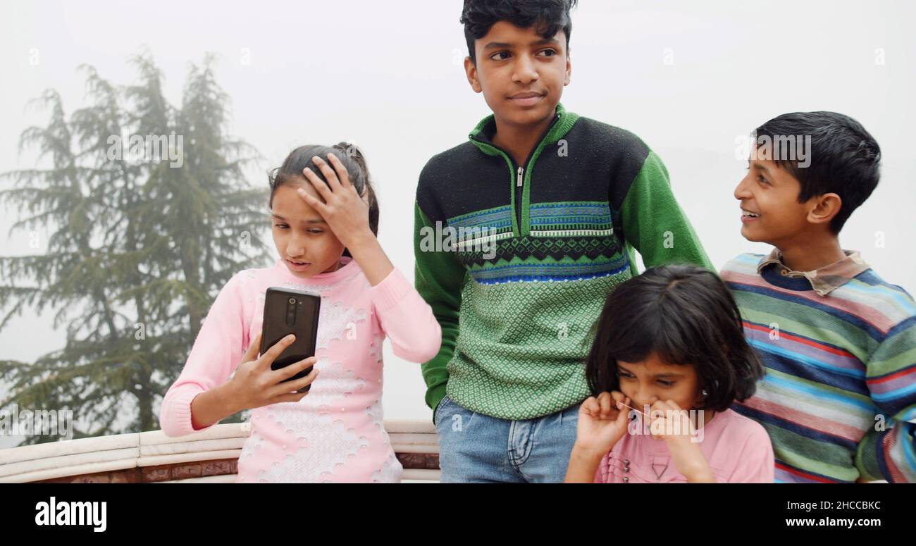 Group of young South Asian friends on a balcony against a foggy ...