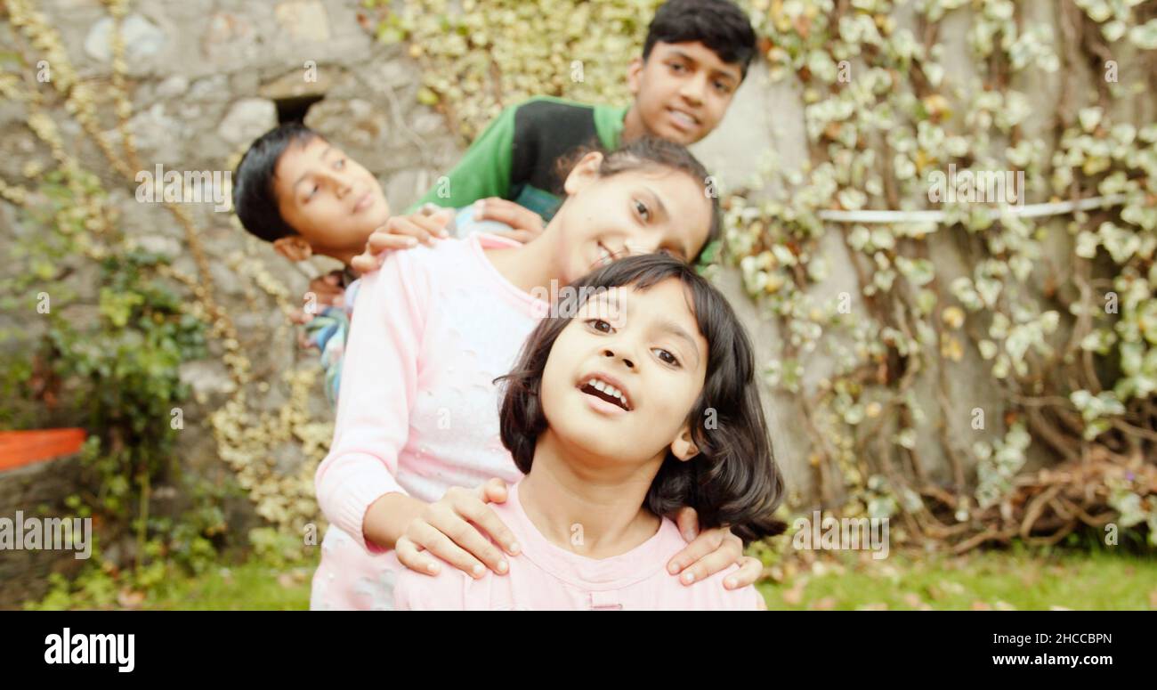 Group of happy young South Asian friends playing in nature in India ...
