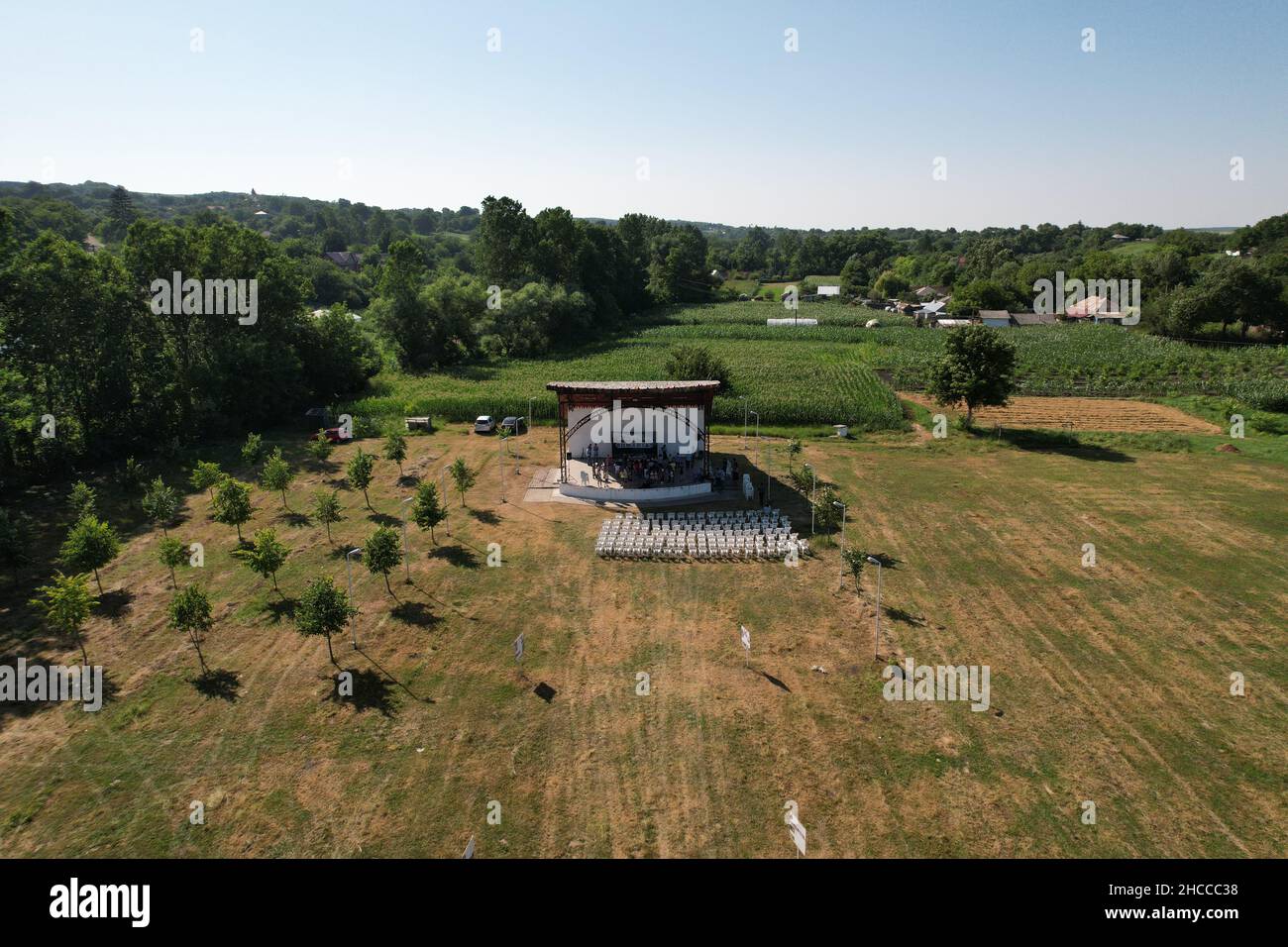 Aerial view of a stage in the middle of a field under a clear blue sky ...