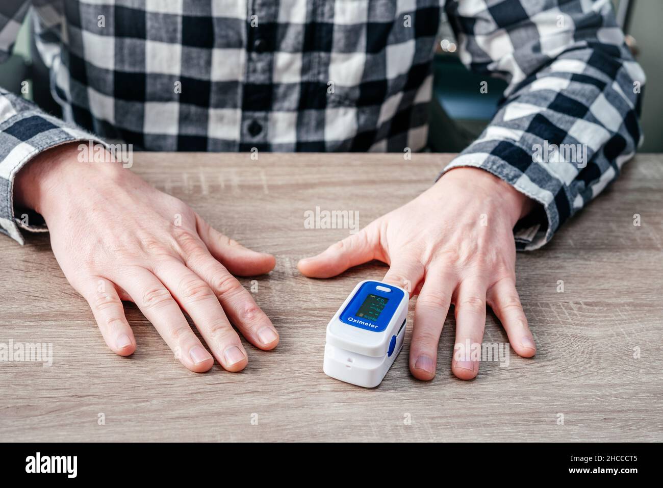 A man checking oxygen level at home with home oximeter, patient ...
