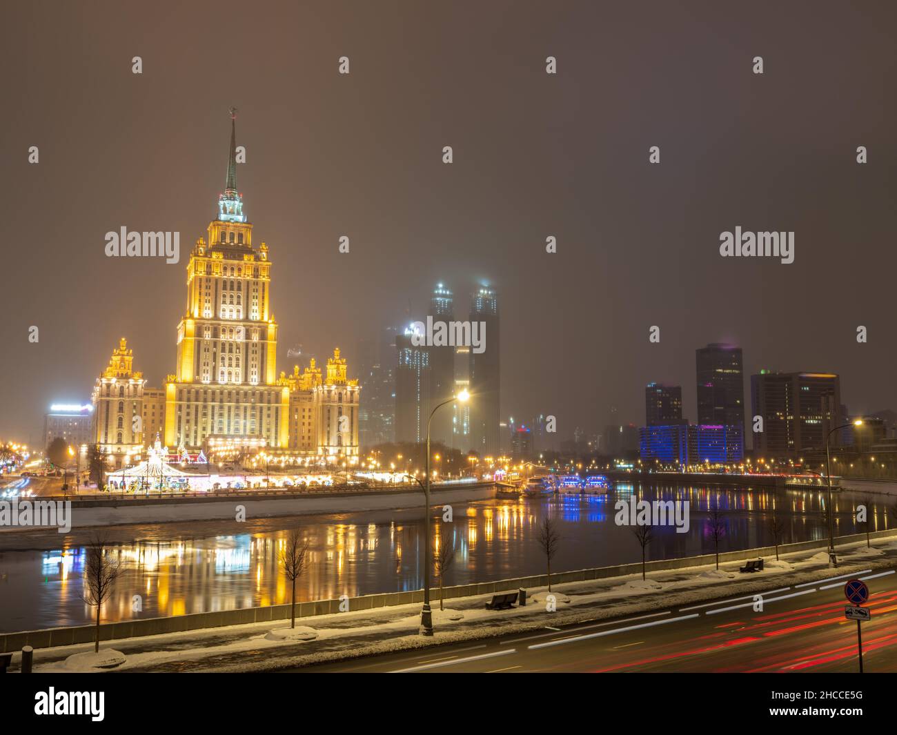 Illuminated high-rise stalinist building near river at winter night in ...
