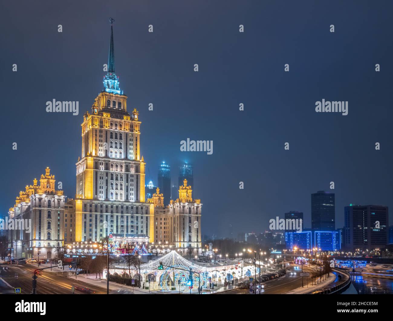 Illuminated high-rise stalinist building near river at winter night in ...