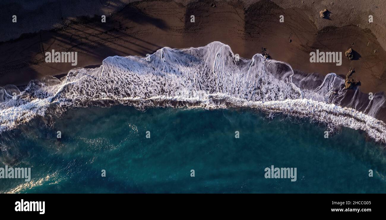 Top down drone shot black sand beach, warm dawn light Stock Photo - Alamy