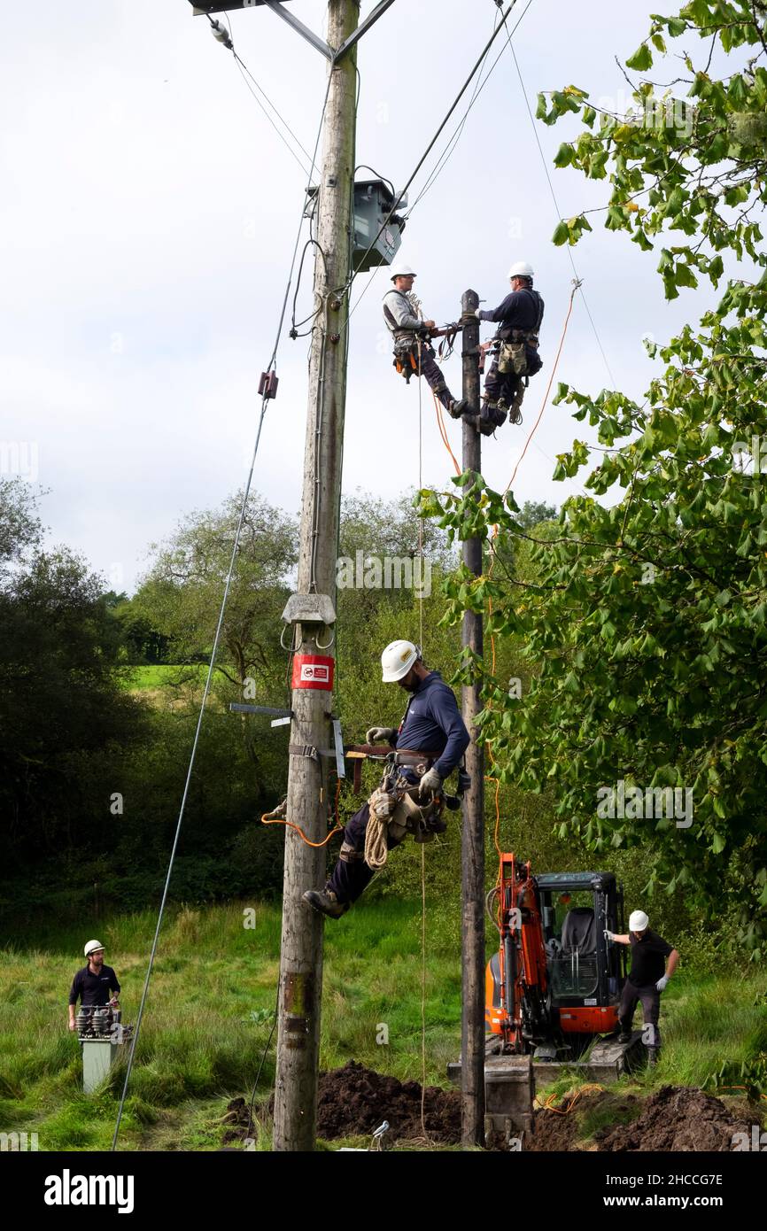 Power workers replacing old utility pole and reconnecting electricity ...