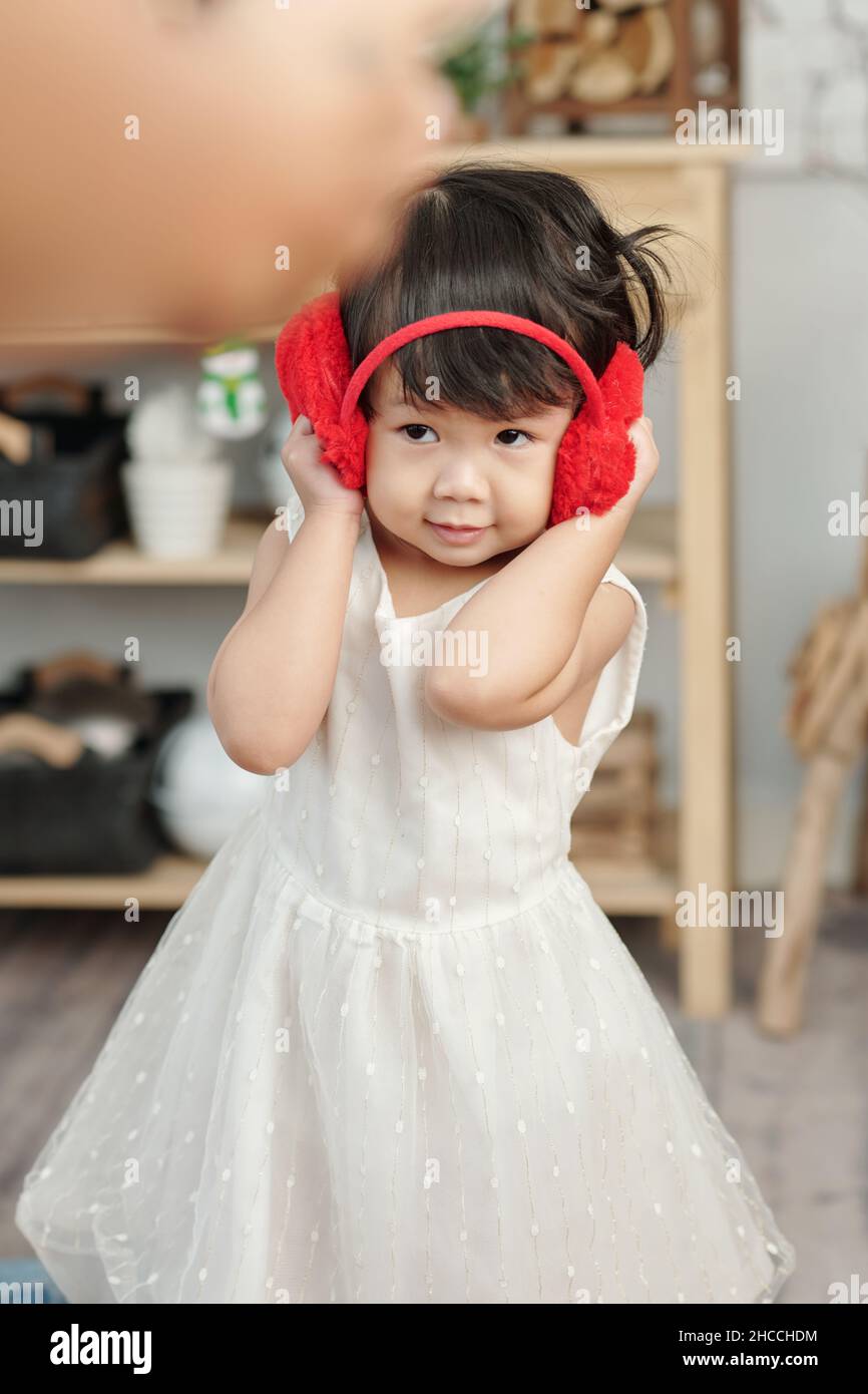 Portrait of shy little girl in white puffy dress and red faux fur ...