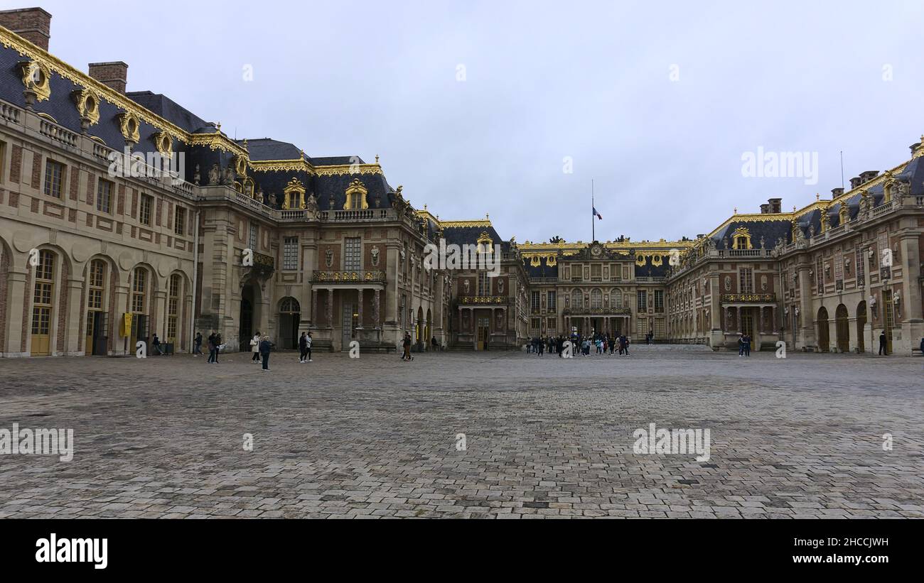 Tourists near the beautiful historical Versailles Palace on a cloudy ...