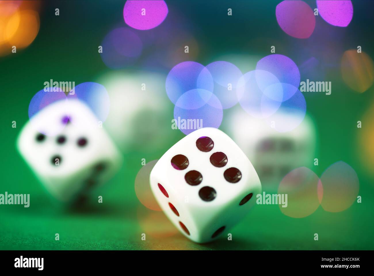White dice on a green felt table with bokeh background Stock Photo - Alamy