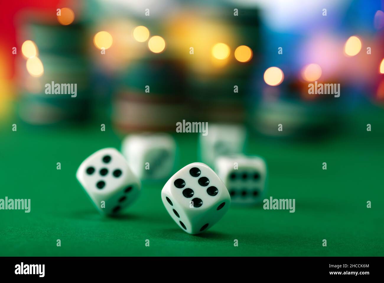 White dice on a green felt table with bokeh background Stock Photo - Alamy