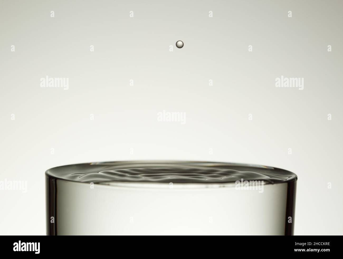 Drop falls down to glass of water liquide beverage, transparent glass ...