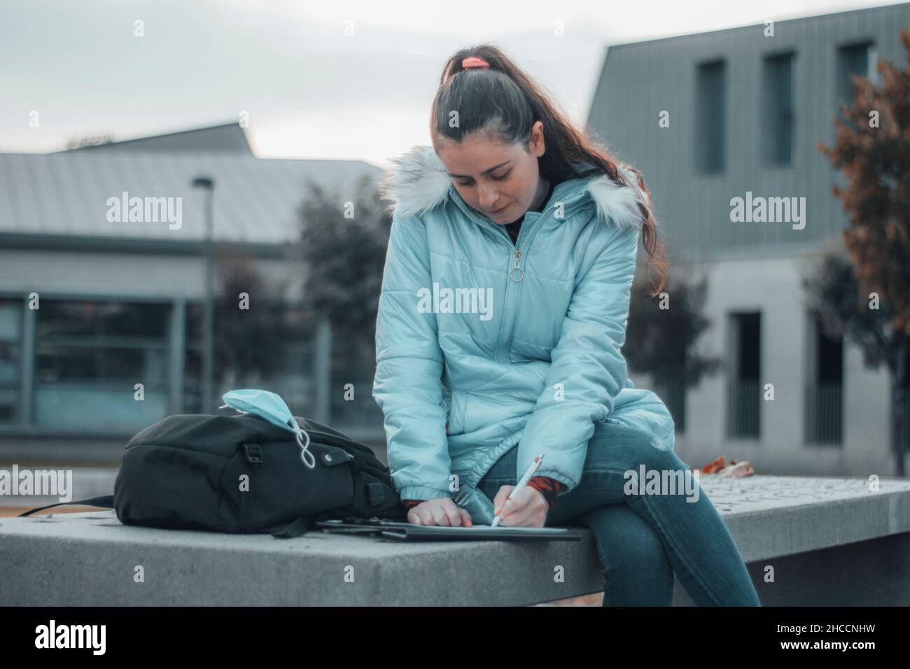 High school student girl making notes and writing sitting in the ...