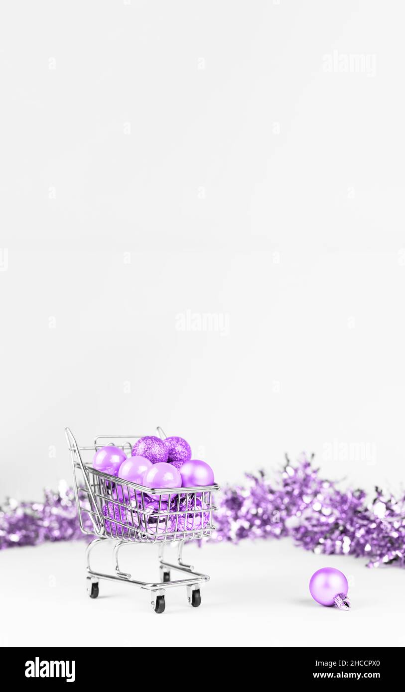 Shopping trolley full of violet very peri Christmas baubles and tinsel ...