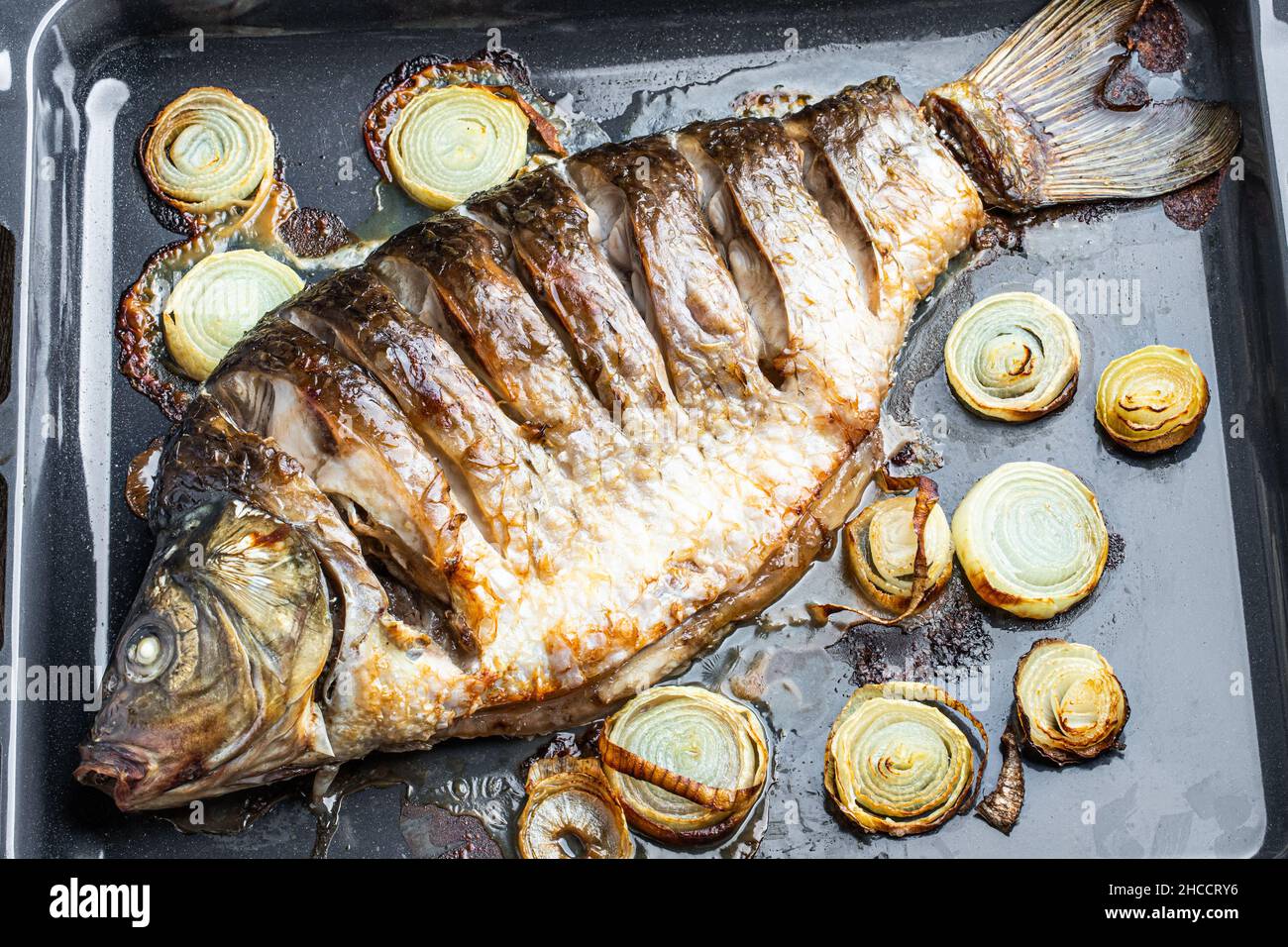 Baked carp fish with onion on baking tray Stock Photo - Alamy
