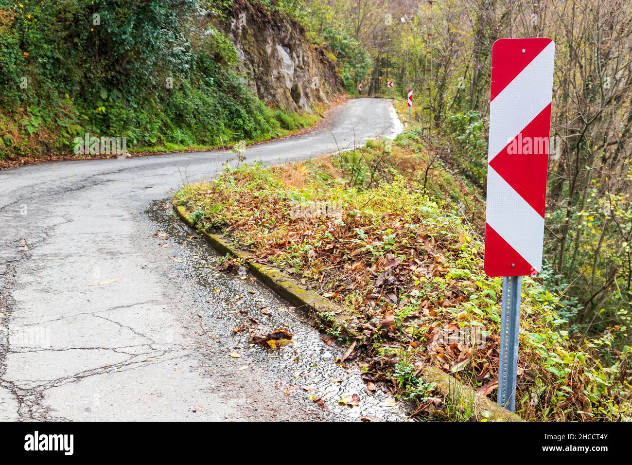 Turn direction, protective road sign is on a turning mountain road ...