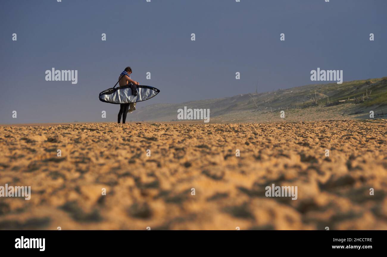 landscape of a large beach with unrecognizable surfers waiting for the ...