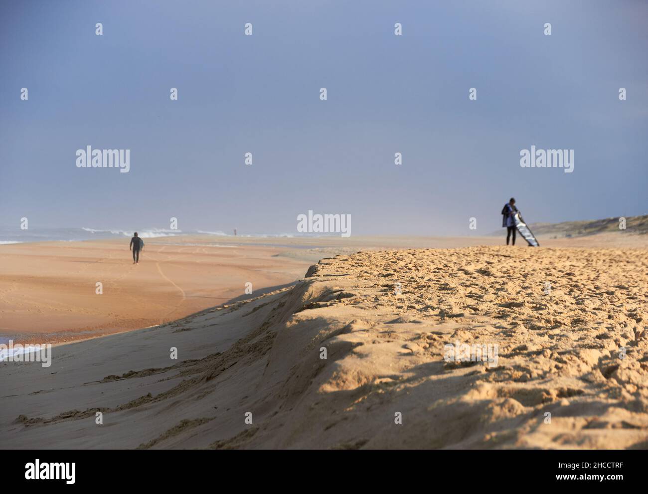 landscape of a large beach with unrecognizable surfers waiting for the ...