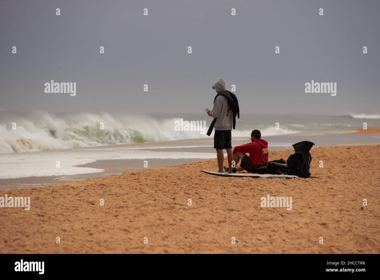 landscape of a large beach with unrecognizable surfers waiting for the ...