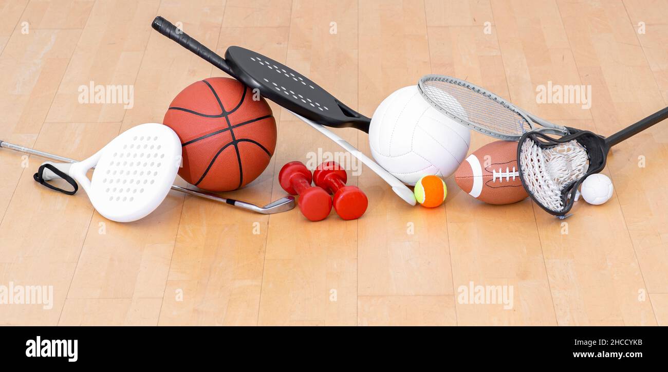 Sports equipment, rackets and balls on hardwood court floor. Horizontal ...