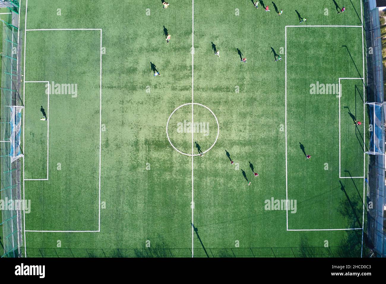 Aerial view of soccer players playing football on green sports stadium ...