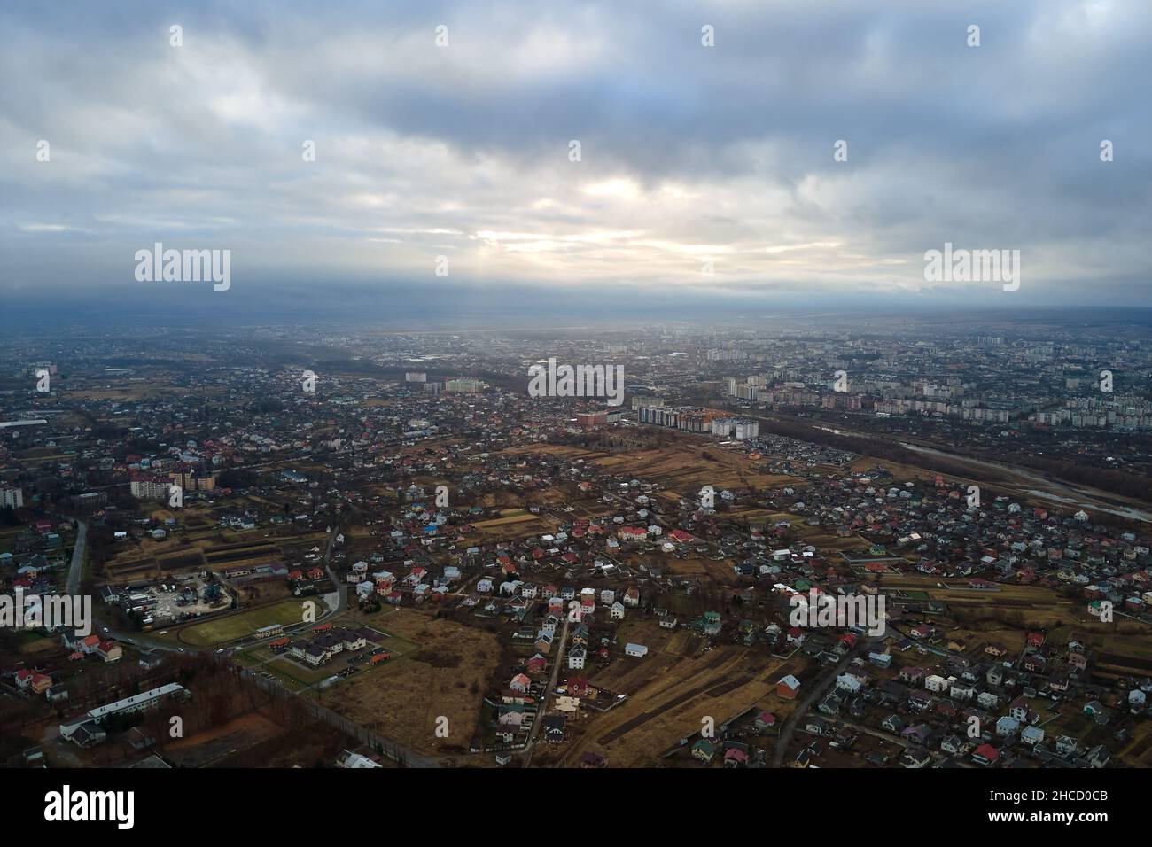 Aerial view of rural homes and distant high rise apartment buildings in ...