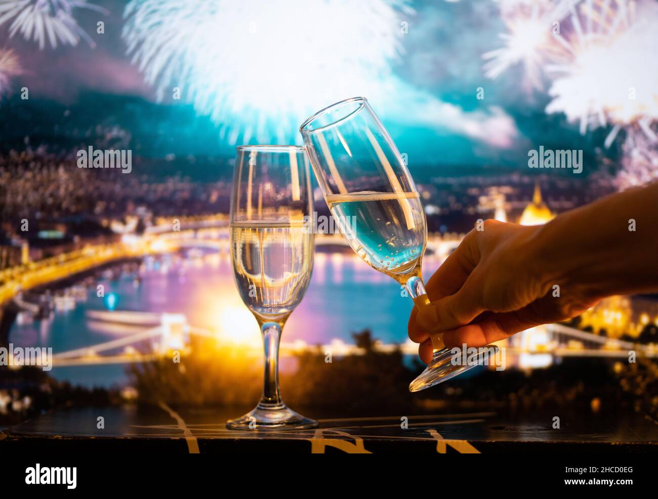 two champagne glasses against fireworks in the city New Year's eve ...