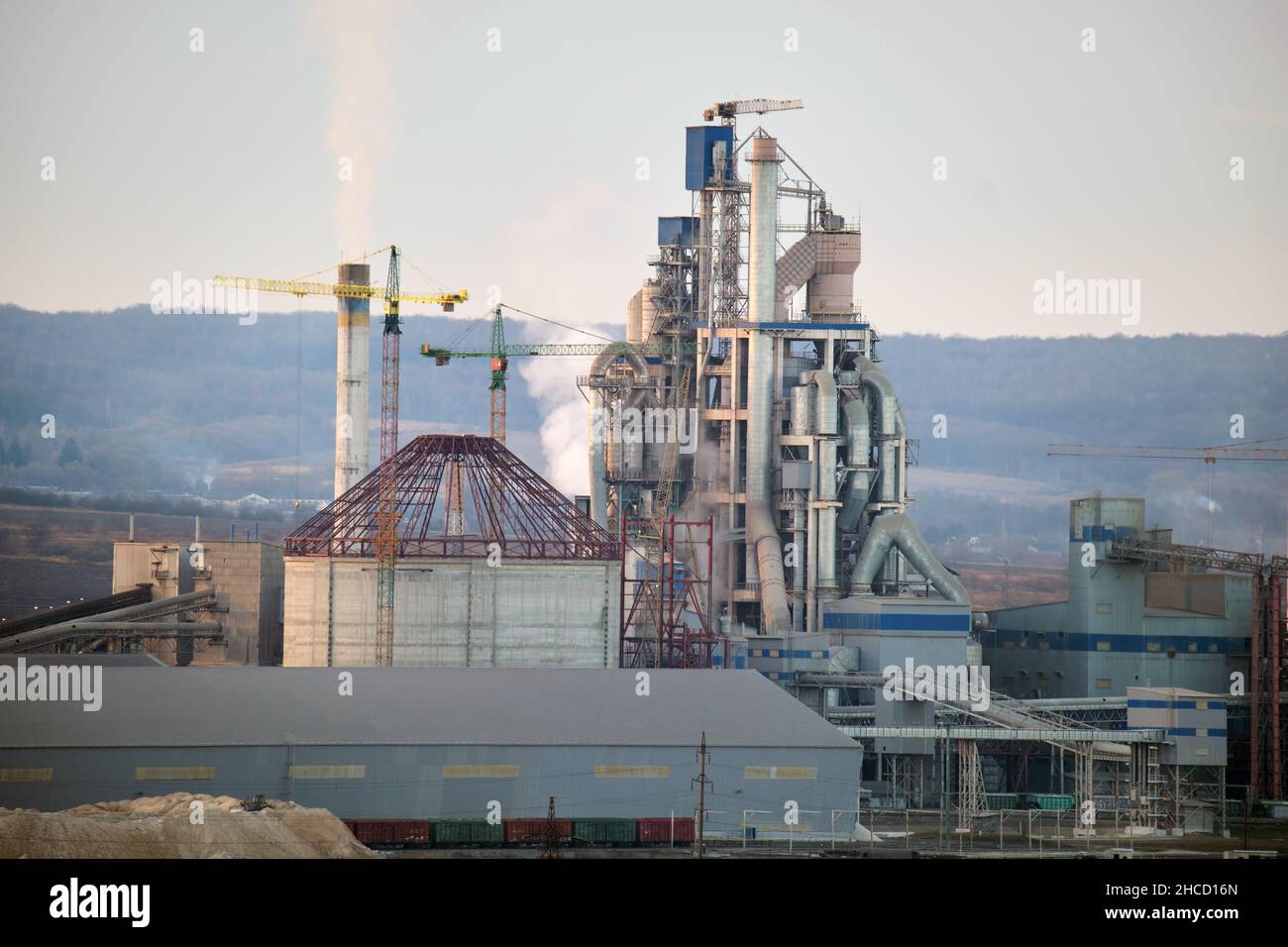 Cement plant with high factory structure and tower cranes at industrial ...