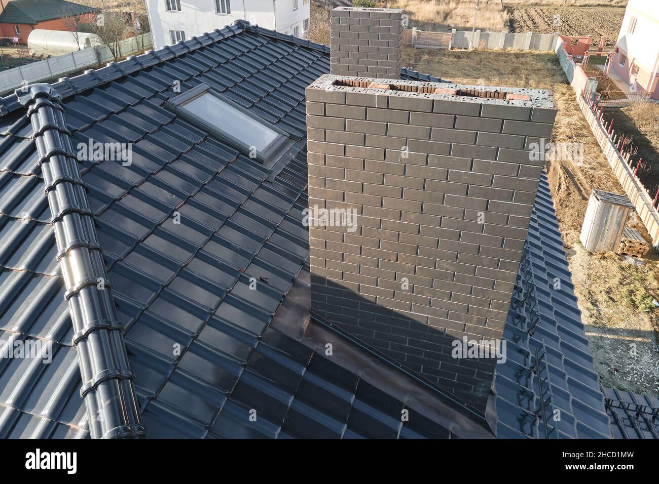Closeup of brick chimney on house roof top covered with ceramic ...