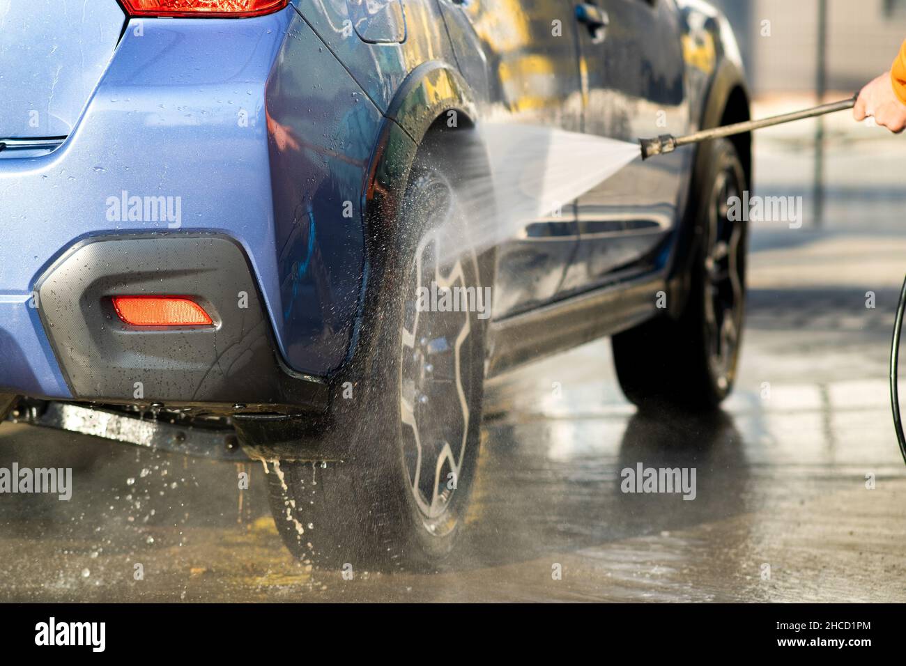 Closeup of male driver washing his car with contactless high pressure ...