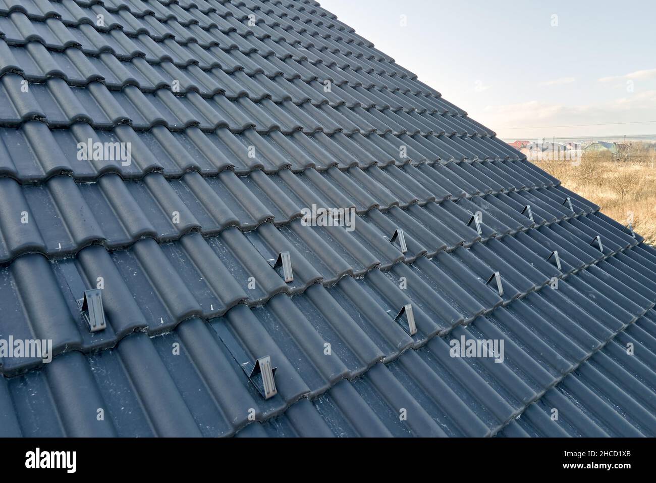 Closeup snow guard for safety in winter on house roof top covered with ...