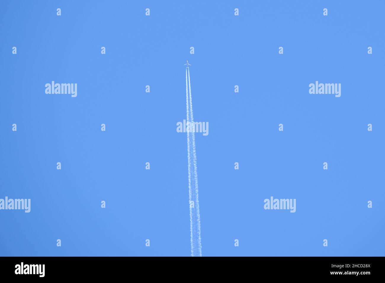 Distant passenger jet plane flying on high altitude on clear blue sky ...