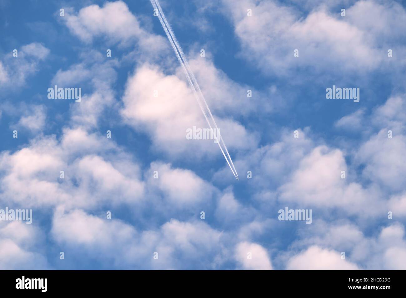 Distant passenger jet plane flying on high altitude through white ...