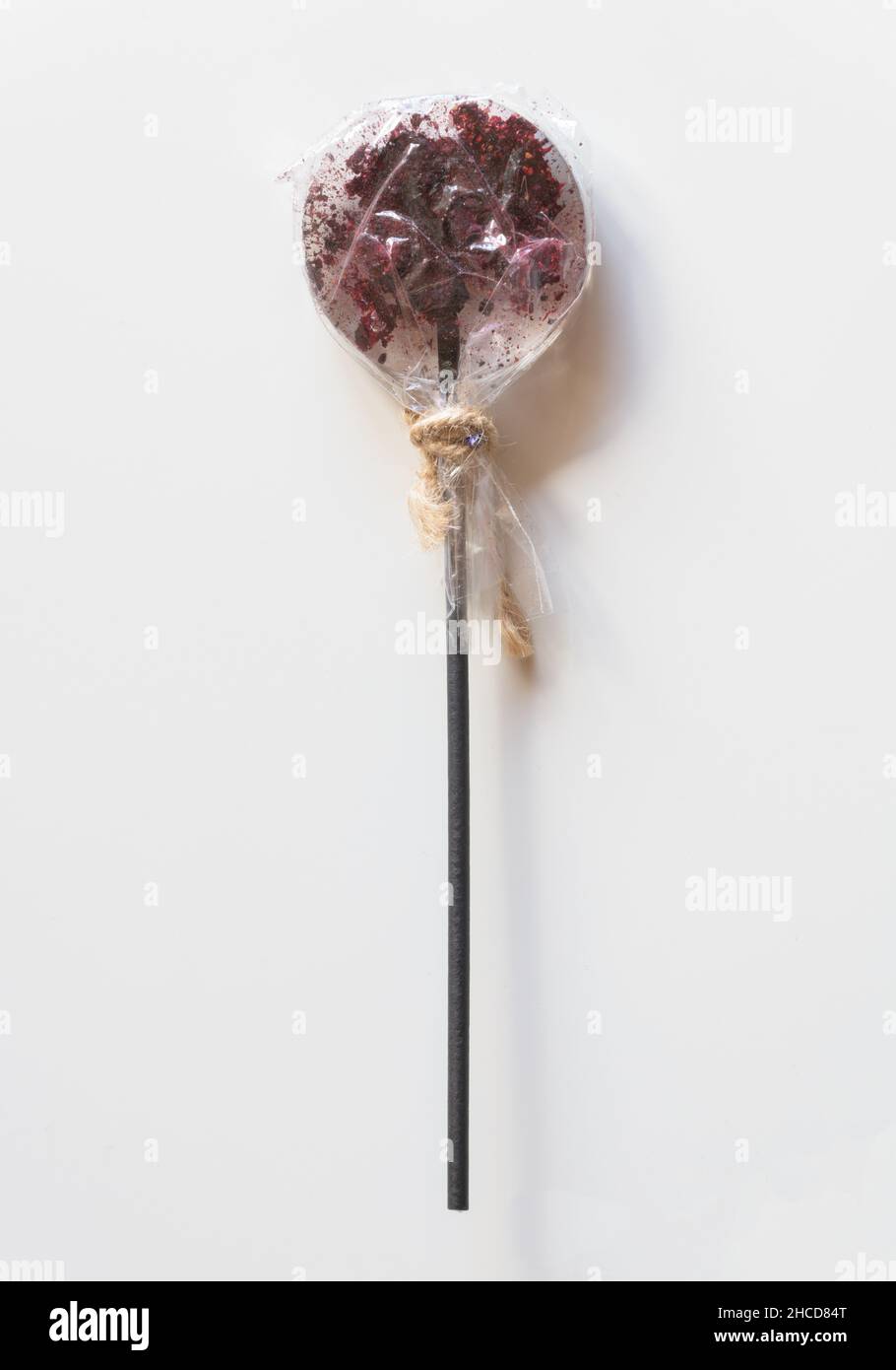 Lollipop on a stick in a transparent wrapper on a white background ...