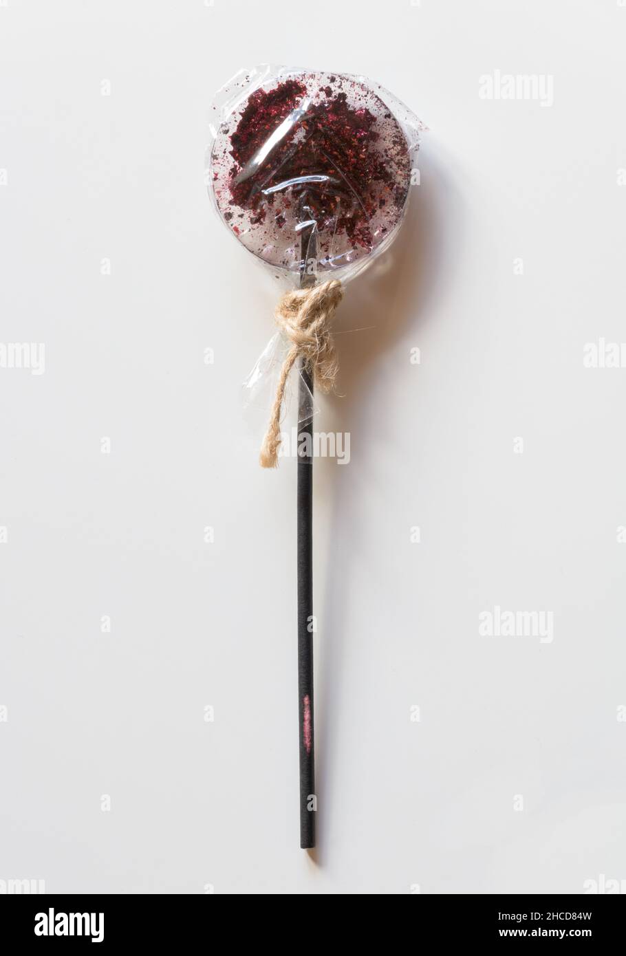 Lollipop on a stick in a transparent wrapper on a white background ...