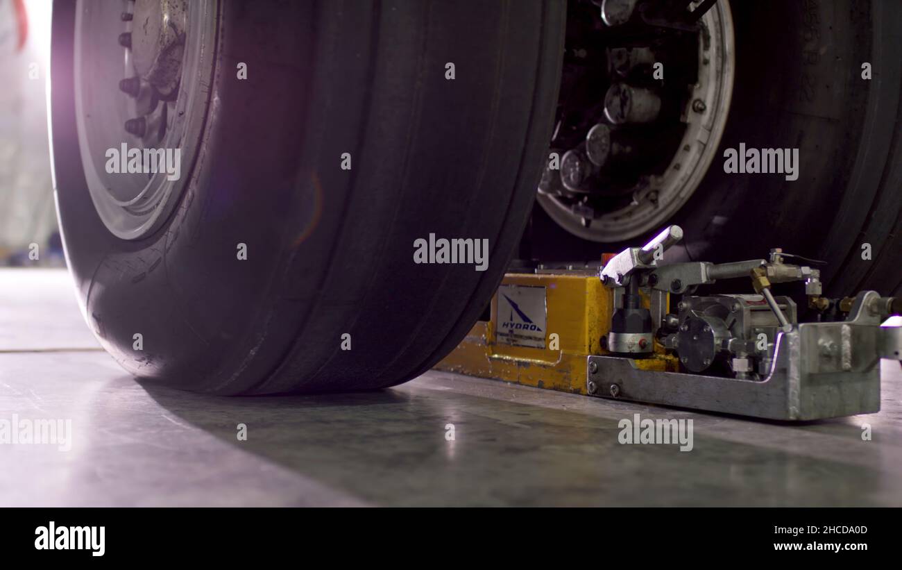 Airport worker checking chassis. Engine and chassis of the passenger ...