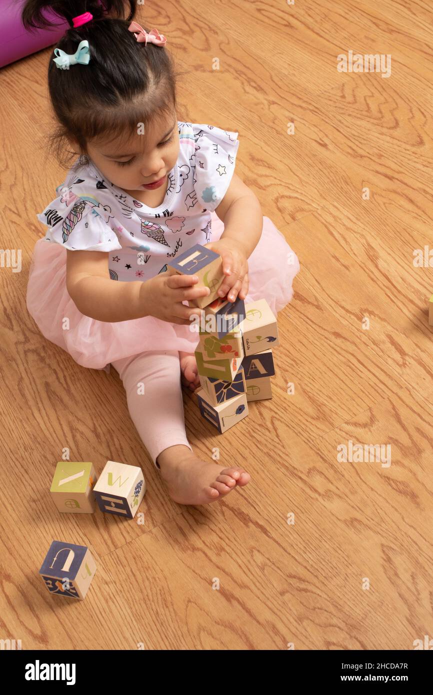 17 month old toddler girl making tower of wooden blocks Stock Photo - Alamy