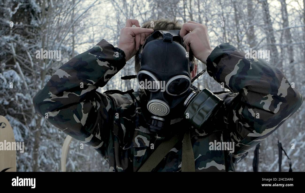 Man in uniform wearing a gas mask in the winter forest. portrait of a ...