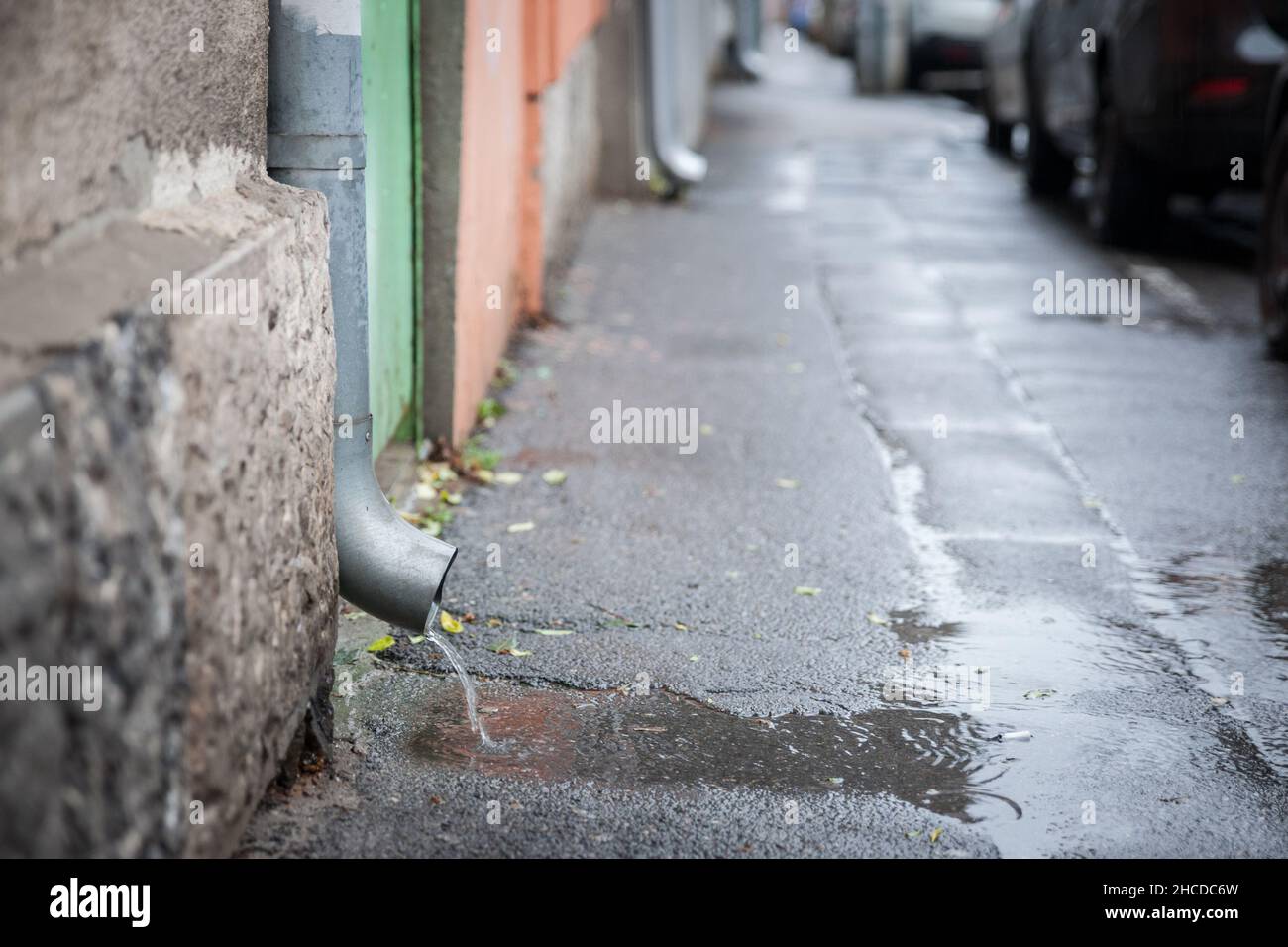 Picture of a gutter flowing water on the sidewalk, during a rainy ...