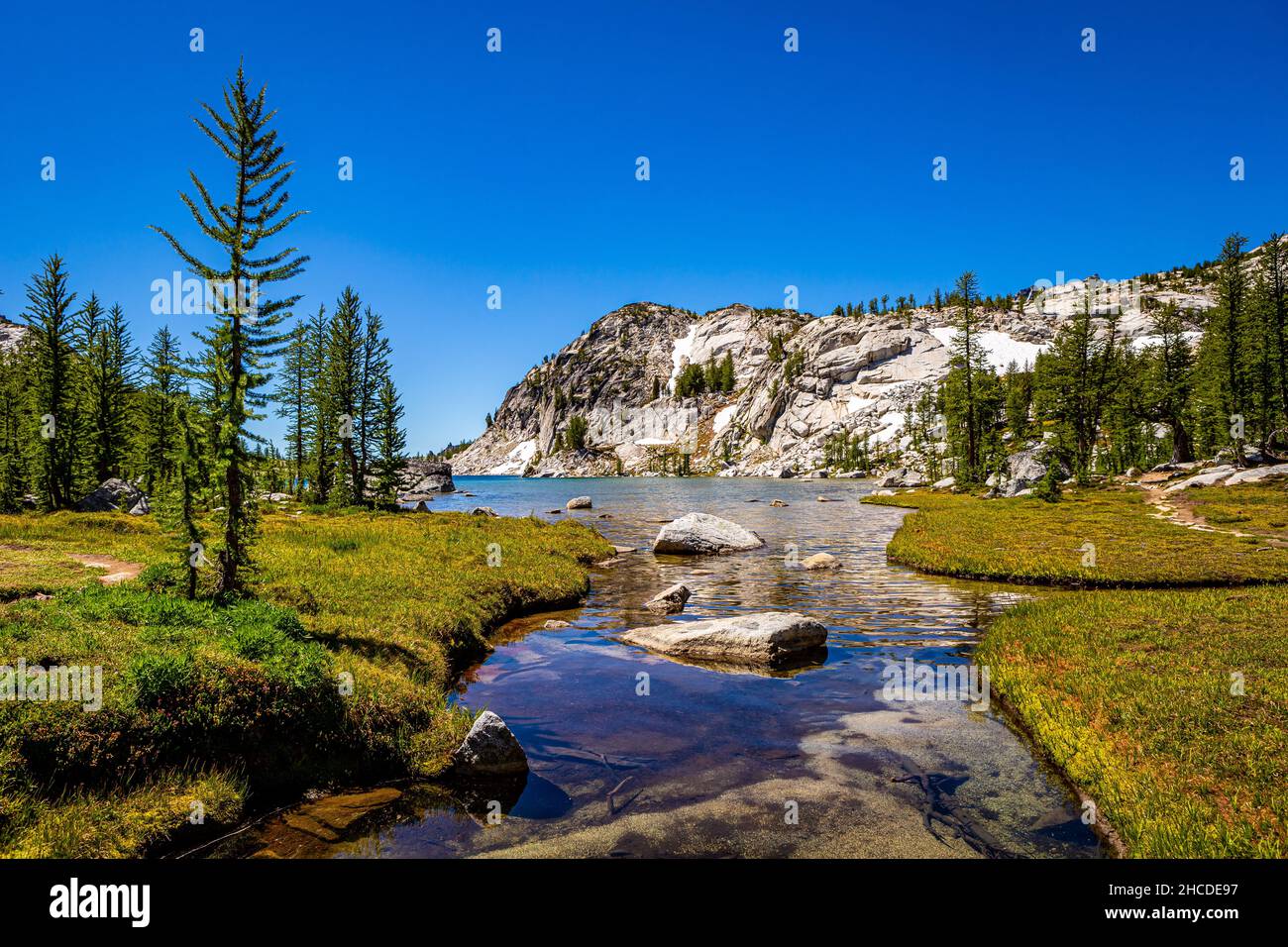 Looking across grass and the stream entering Perfection Lake from the ...